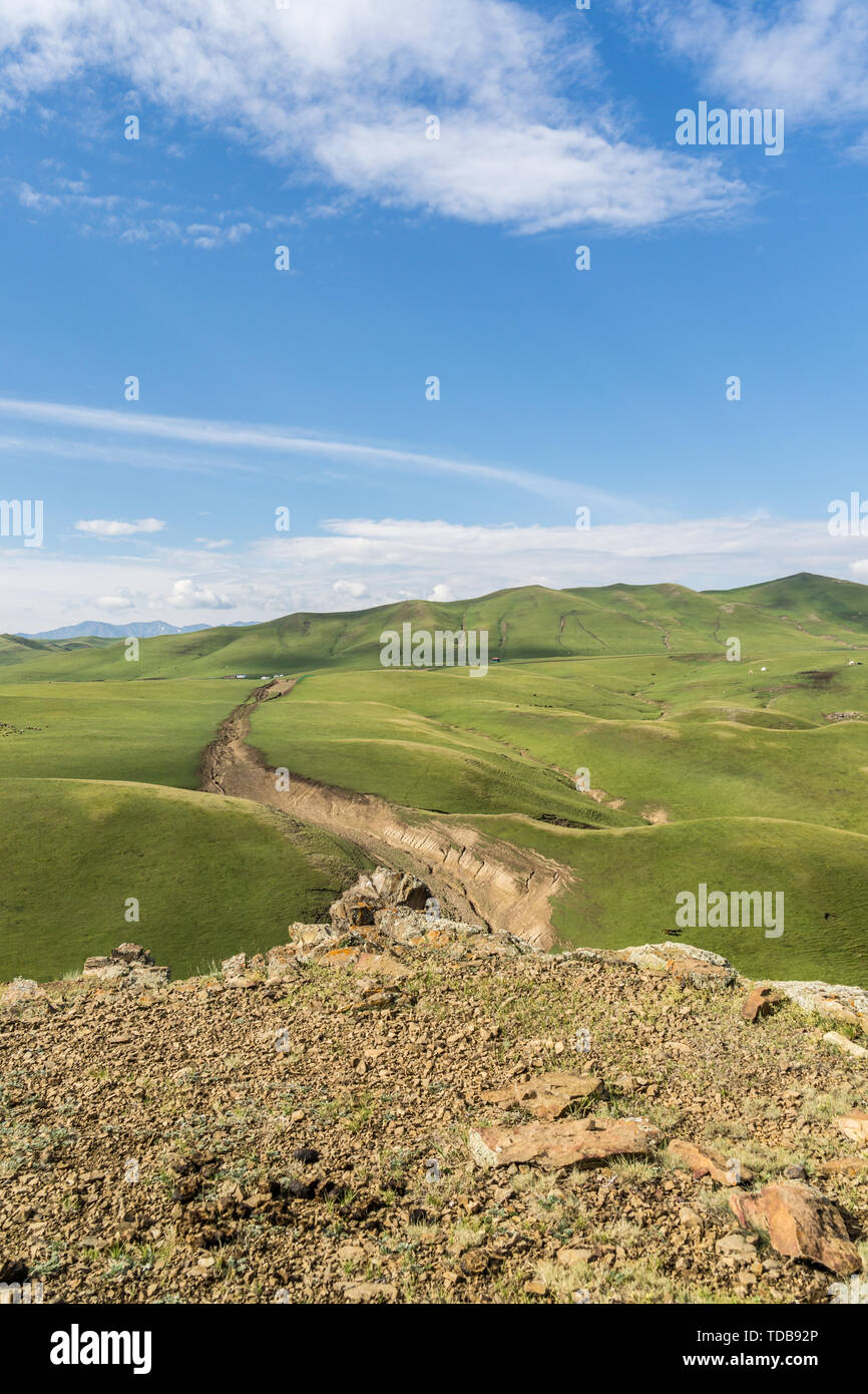 Hillside Prairie Road under blue sky and white clouds Stock Photo - Alamy