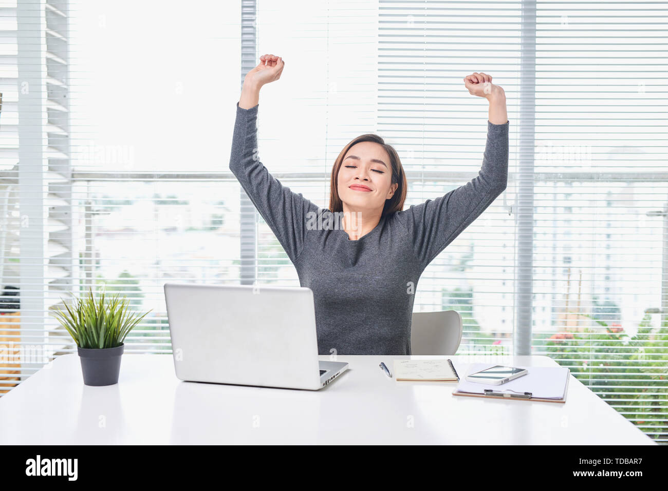 Satisfied woman relaxing with hands behind her head. Happy smiling ...