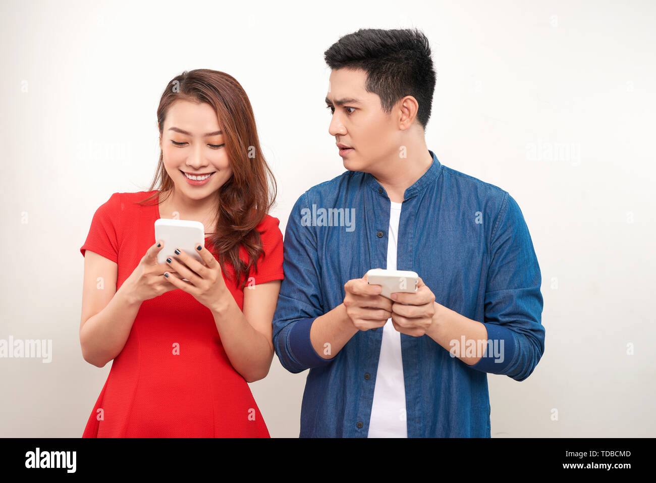 Asian couple using gadgets: pretty girl typing a message on cell phone ...