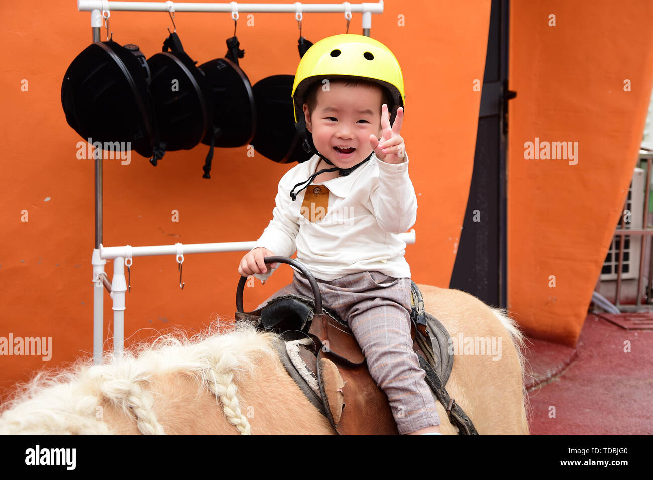 Happy little baby riding a pony Stock Photo - Alamy