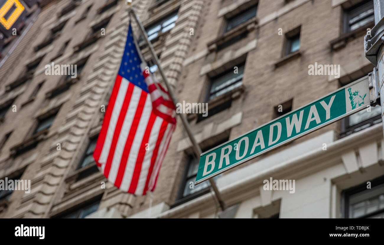 Broadway street sign. Blur American flag and buildings facade ...
