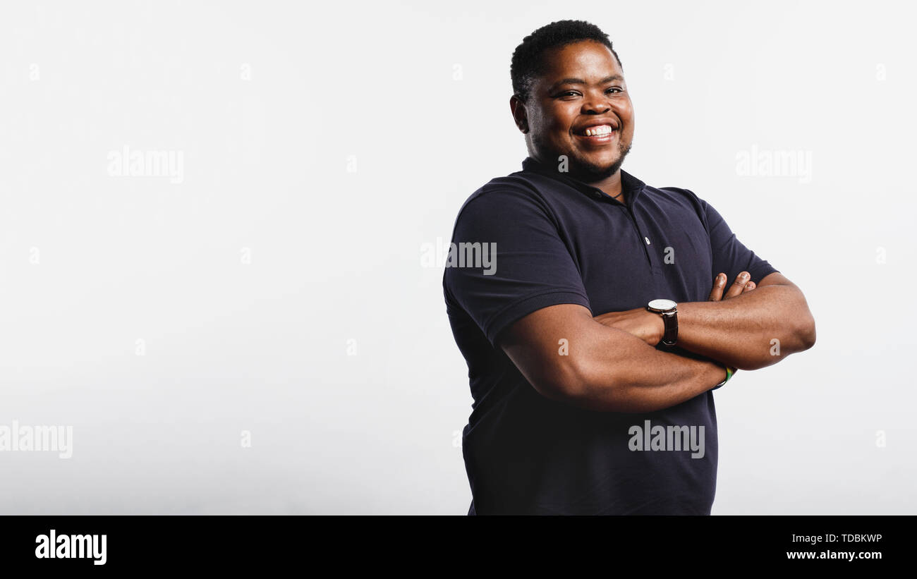 Strong african man standing against white background looking at camera ...