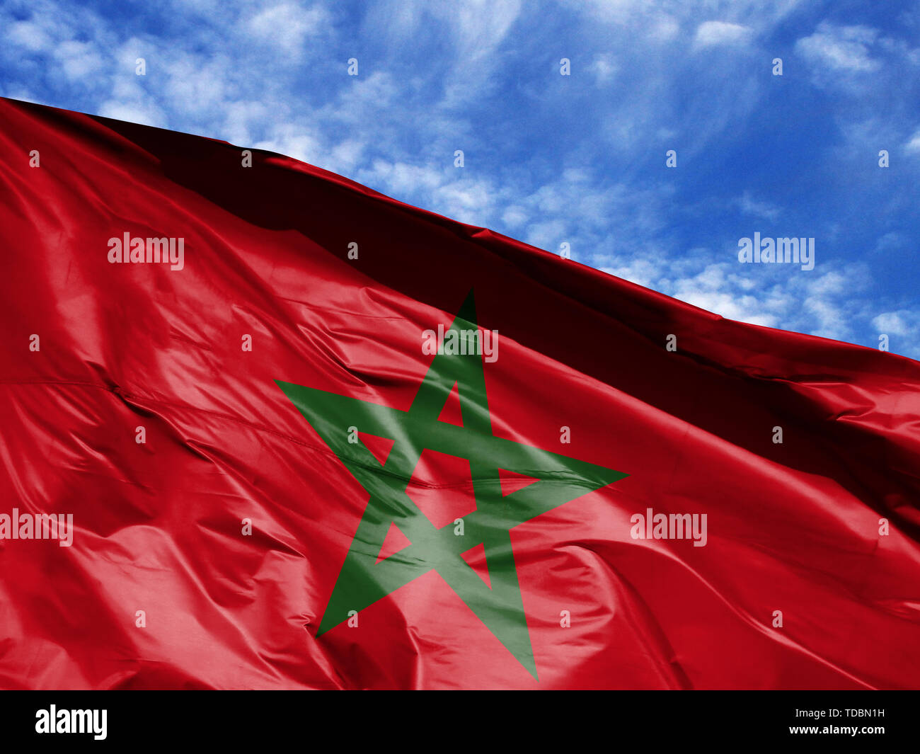 waving flag of Morocco close up against blue sky Stock Photo - Alamy