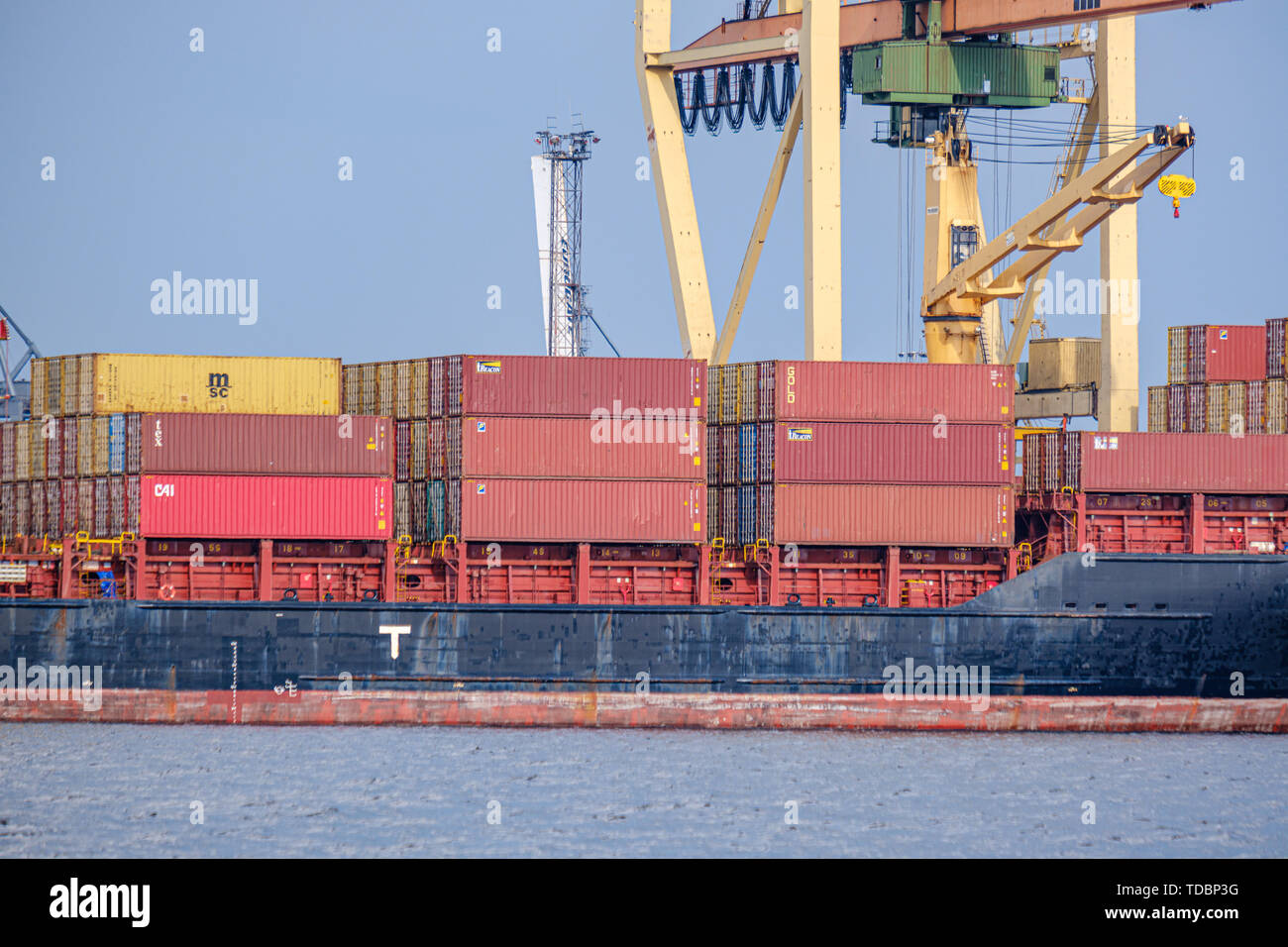 cargo shipping terminals in Riga, Latvia with high wind and dust flying over with cranes and ...
