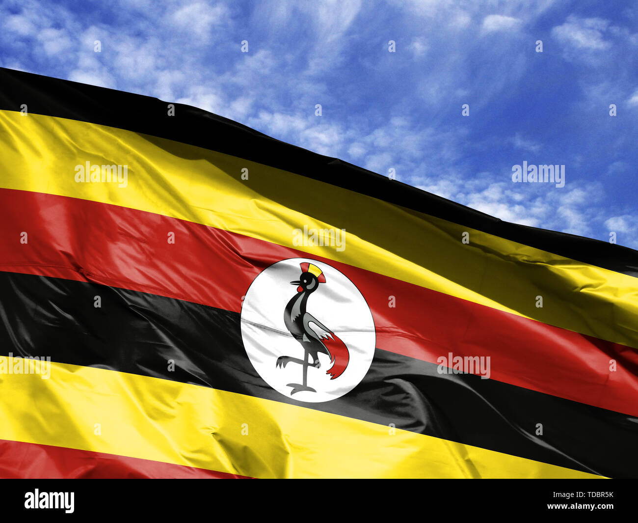 waving flag of Uganda close up against blue sky Stock Photo - Alamy