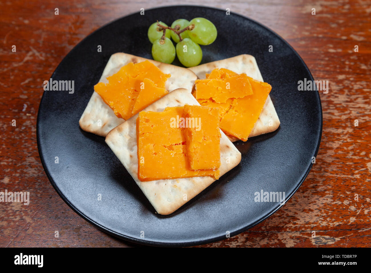 Plate of Crackers with Red Leicester Cheese with green grapes Stock ...