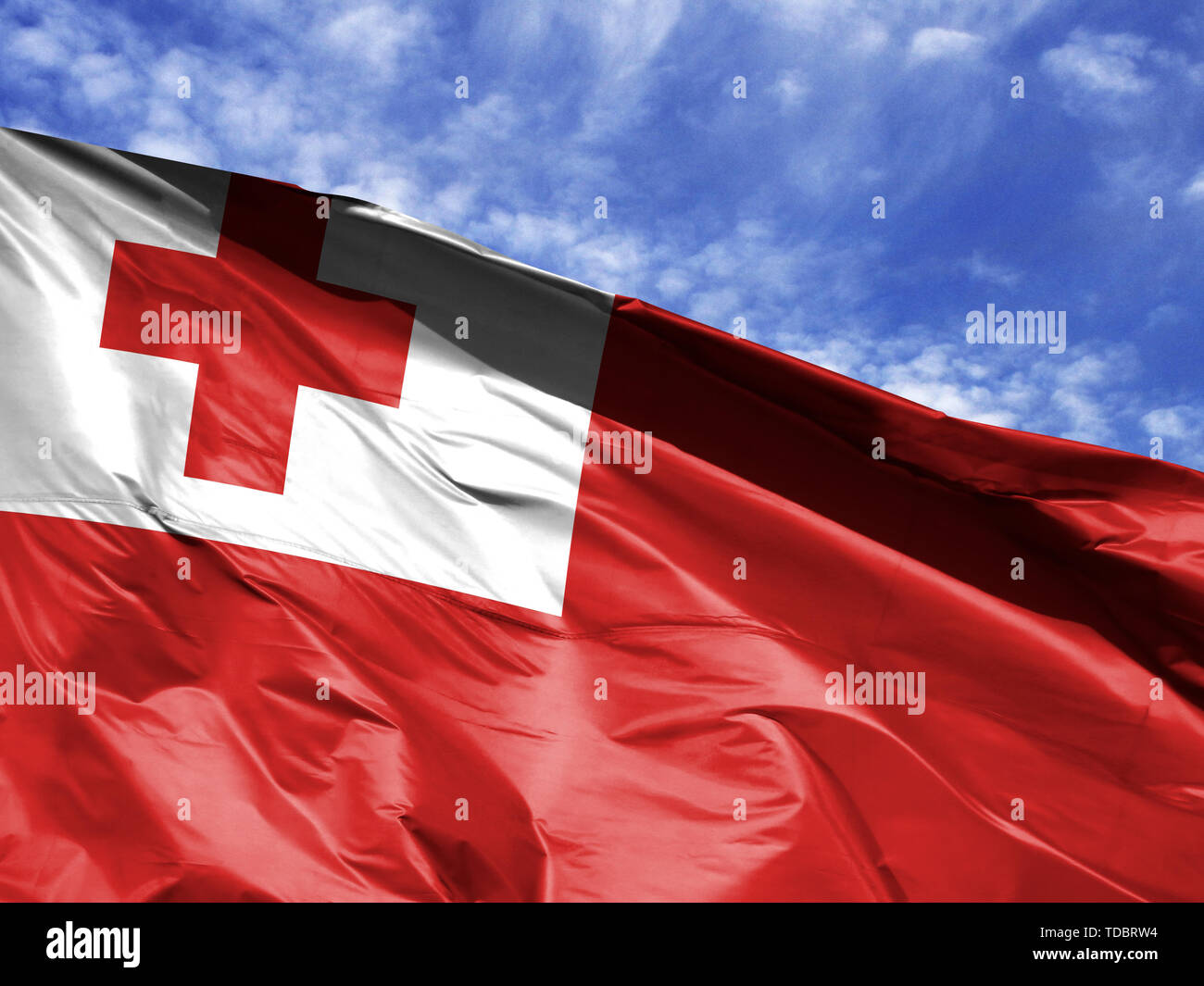 waving flag of Tonga close up against blue sky Stock Photo - Alamy