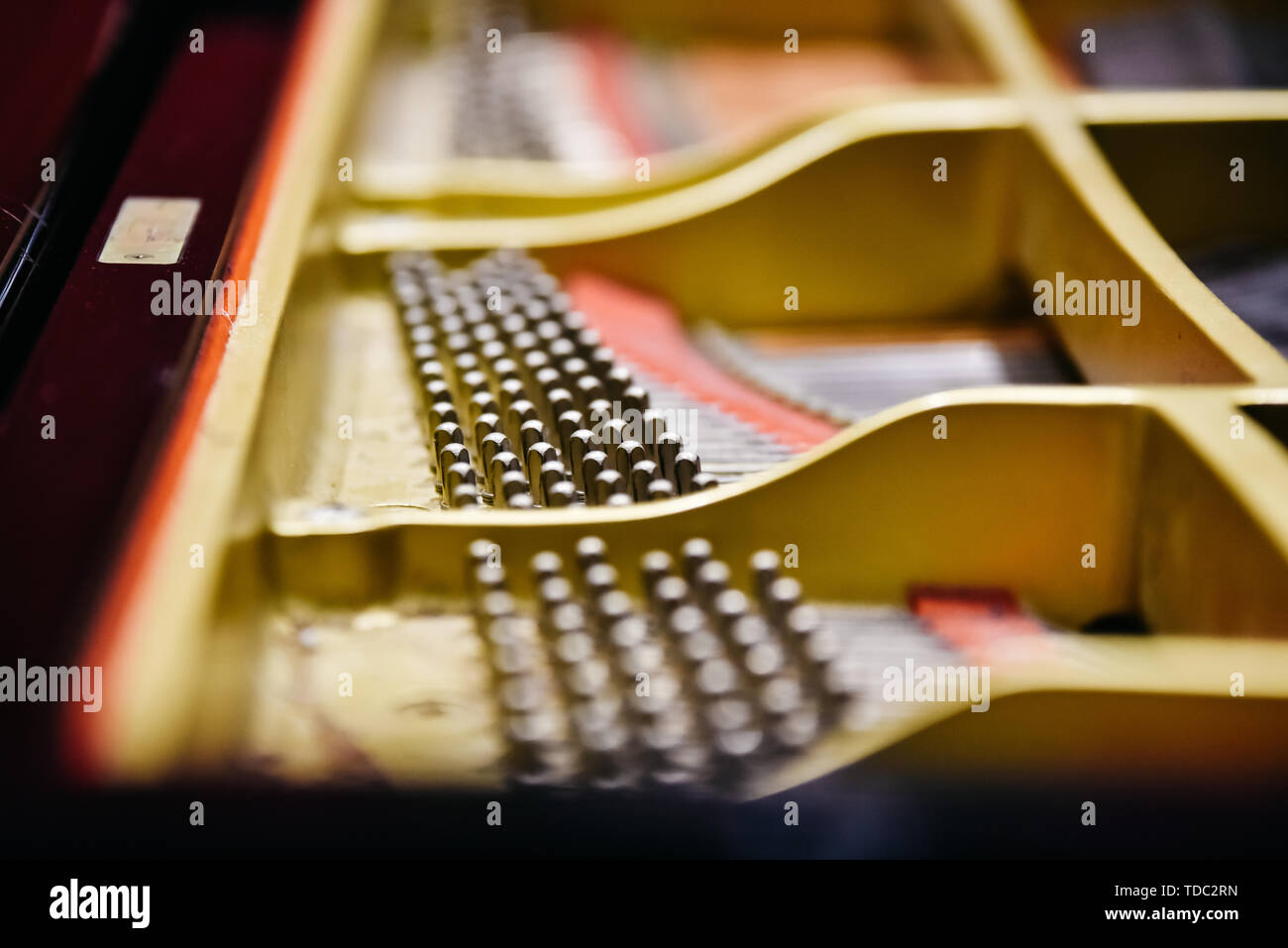Detail of the interior of a piano with the soundboard, strings and pins ...