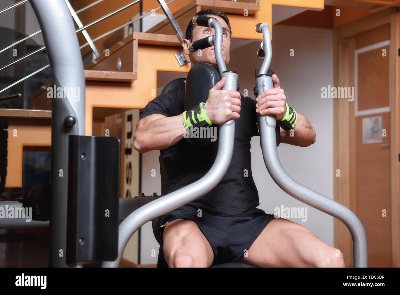 Handsome muscular man working out hard at gym. Training Chest exercises ...
