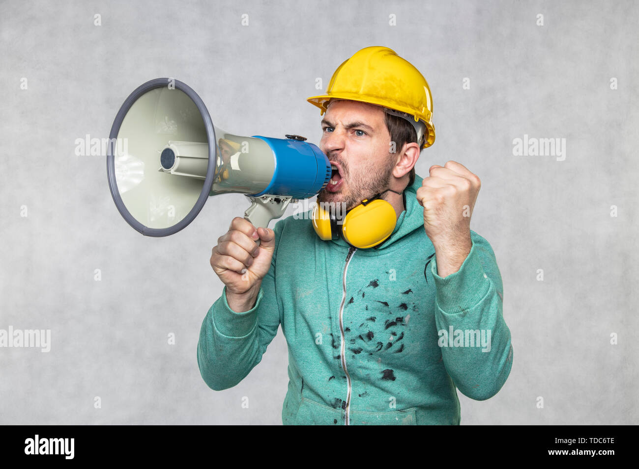 the construction worker holds a megaphone in his hands, the concept of ...