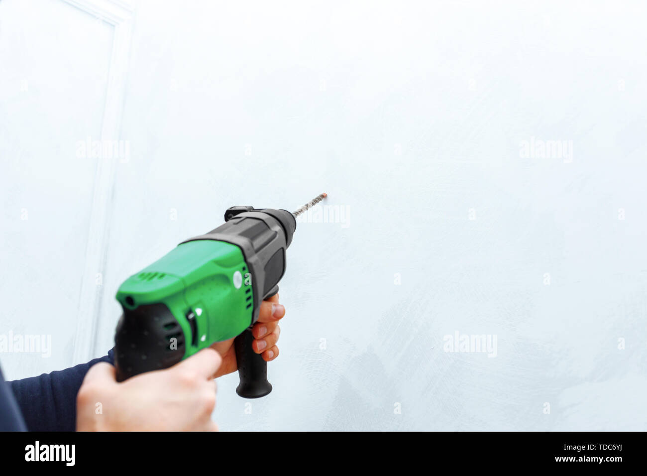 Use hammer drill to drill the wall Stock Photo - Alamy
