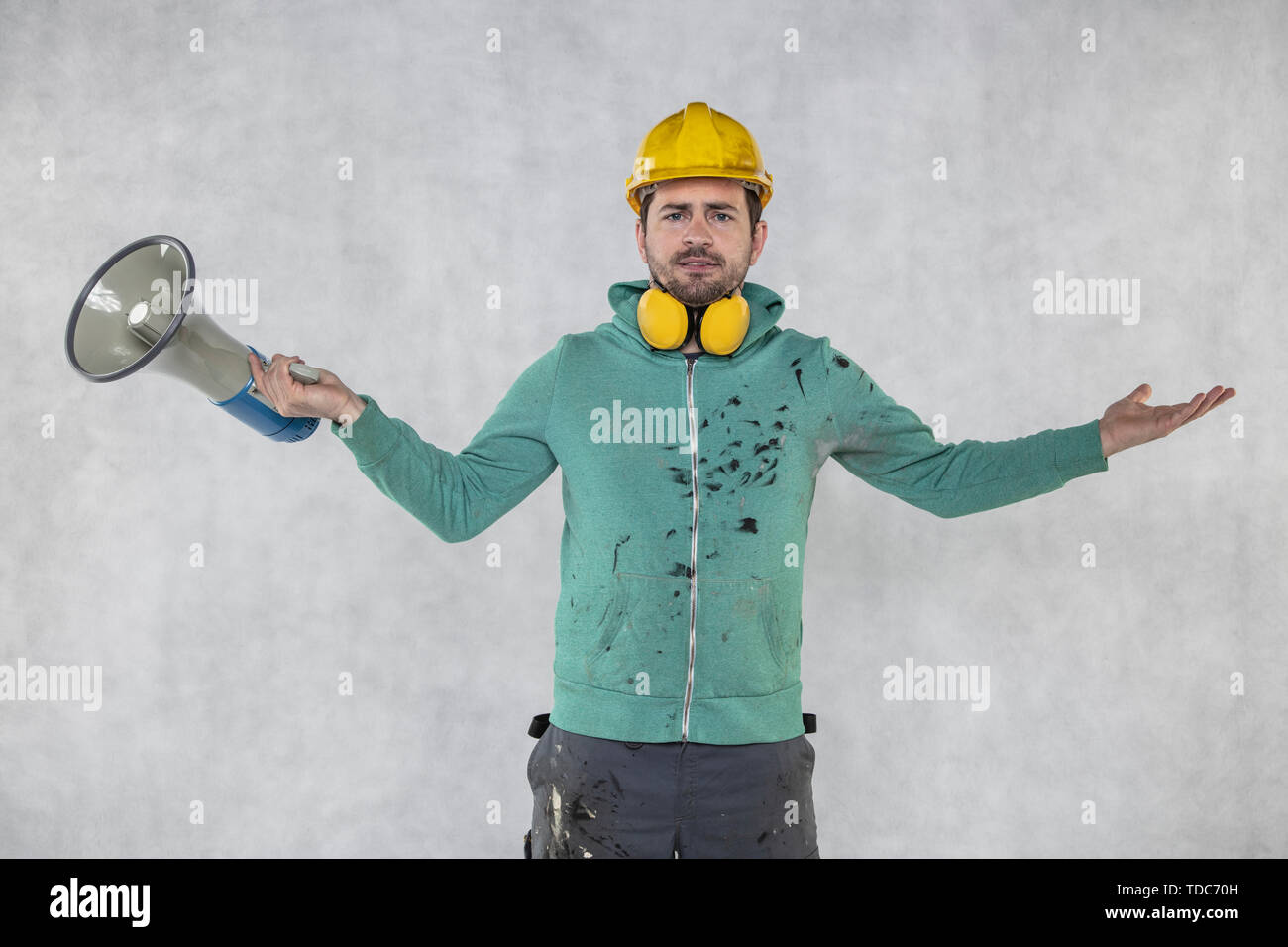 the construction worker holds a megaphone in his hands, the concept of ...