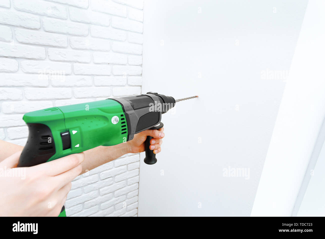 Use hammer drill to drill the wall Stock Photo - Alamy