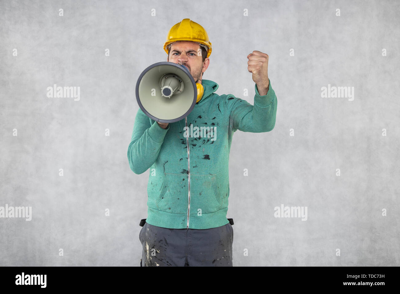 the construction worker holds a megaphone in his hands, the concept of ...