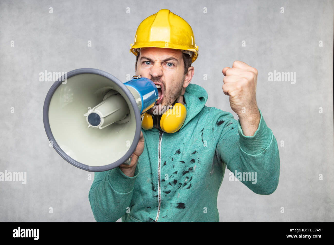 the construction worker holds a megaphone in his hands, the concept of ...