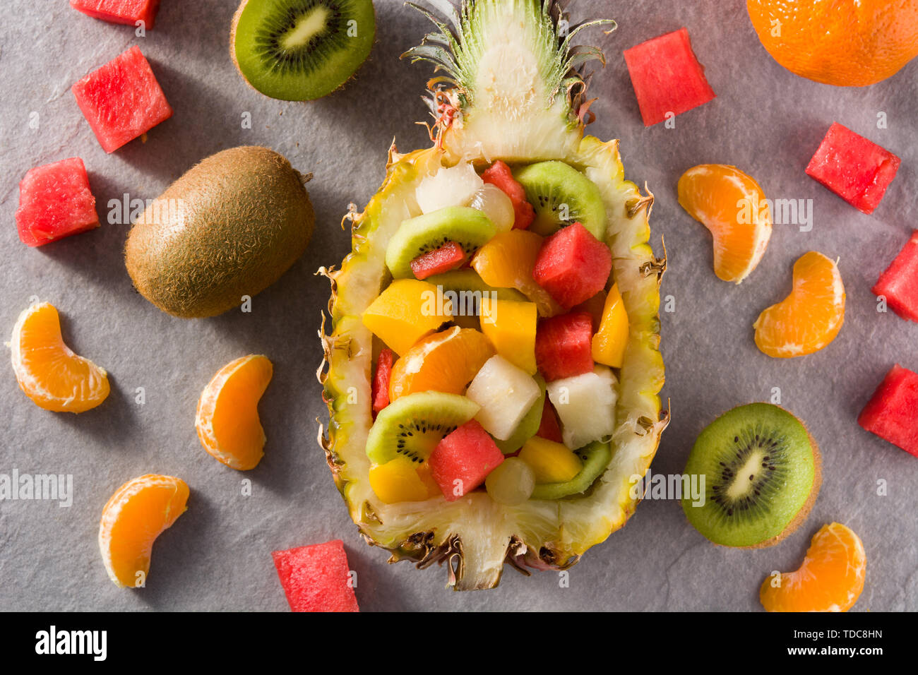 Mix fruit served inside pineapple on gray background Stock Photo - Alamy