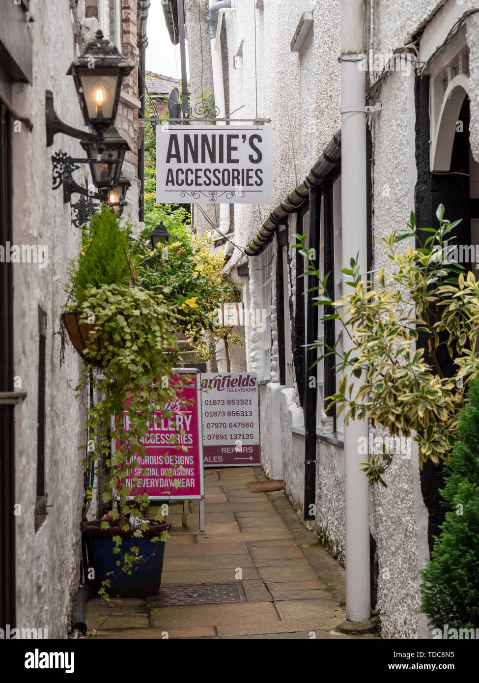 A narrow alleyway and street with independent shops at Abergavenny UK ...