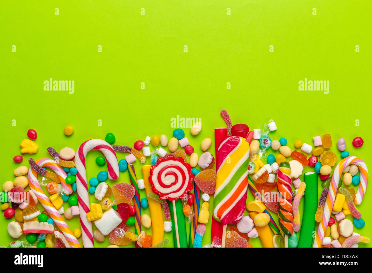 Colorful candies on green background Stock Photo - Alamy