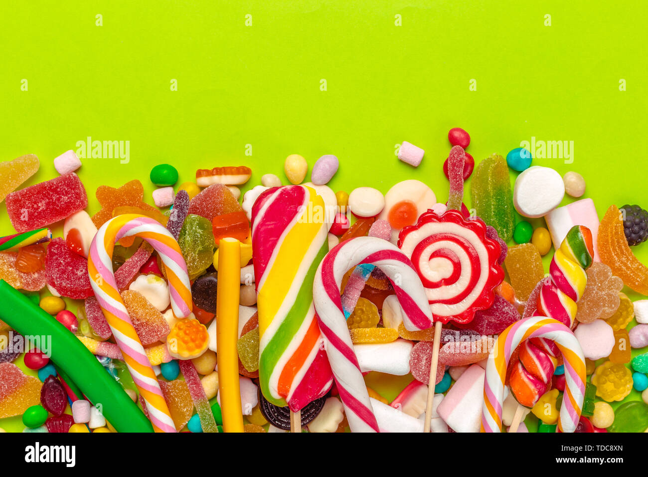 Colorful candies on green background Stock Photo - Alamy