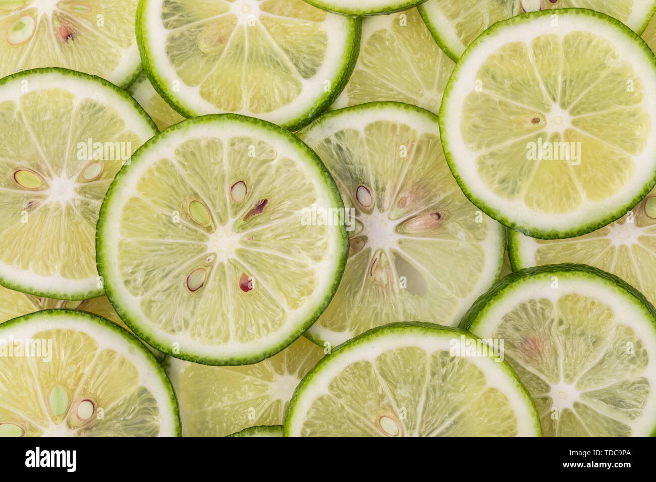 Green lemon slices on white background Stock Photo - Alamy