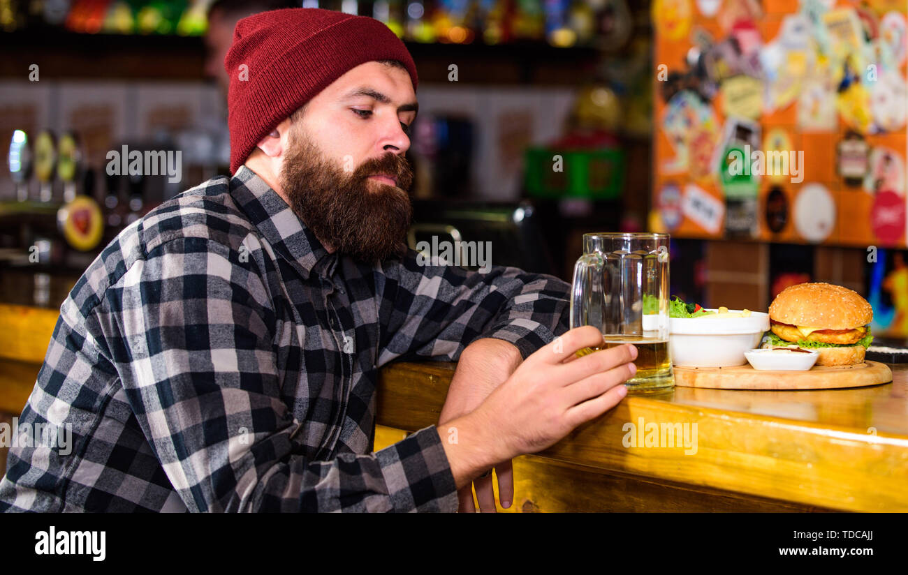 Brutal hipster bearded man sit at bar counter. Hipster relaxing at pub ...