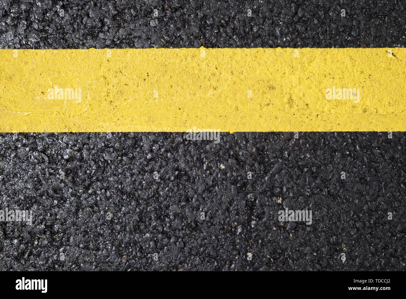 Yellow line painted on the asphalt Stock Photo - Alamy
