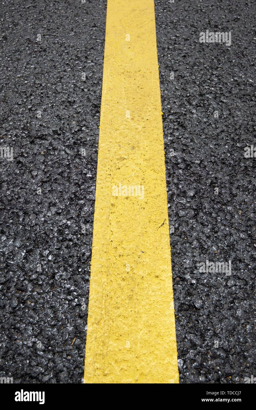 Yellow line painted on the asphalt Stock Photo - Alamy