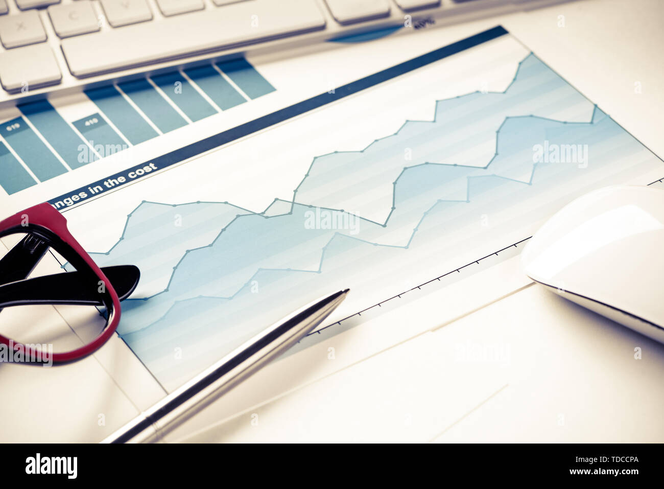 Business workplace with keyboard mouse and papers with graphs and ...