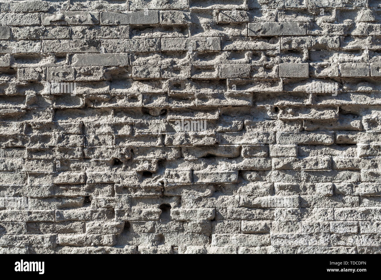 Gray old brick walls, mottled surfaces eroded by wind and rain ...