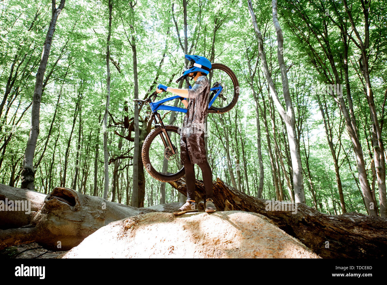 Professional cyclist carrying bicycle while riding off road in the ...