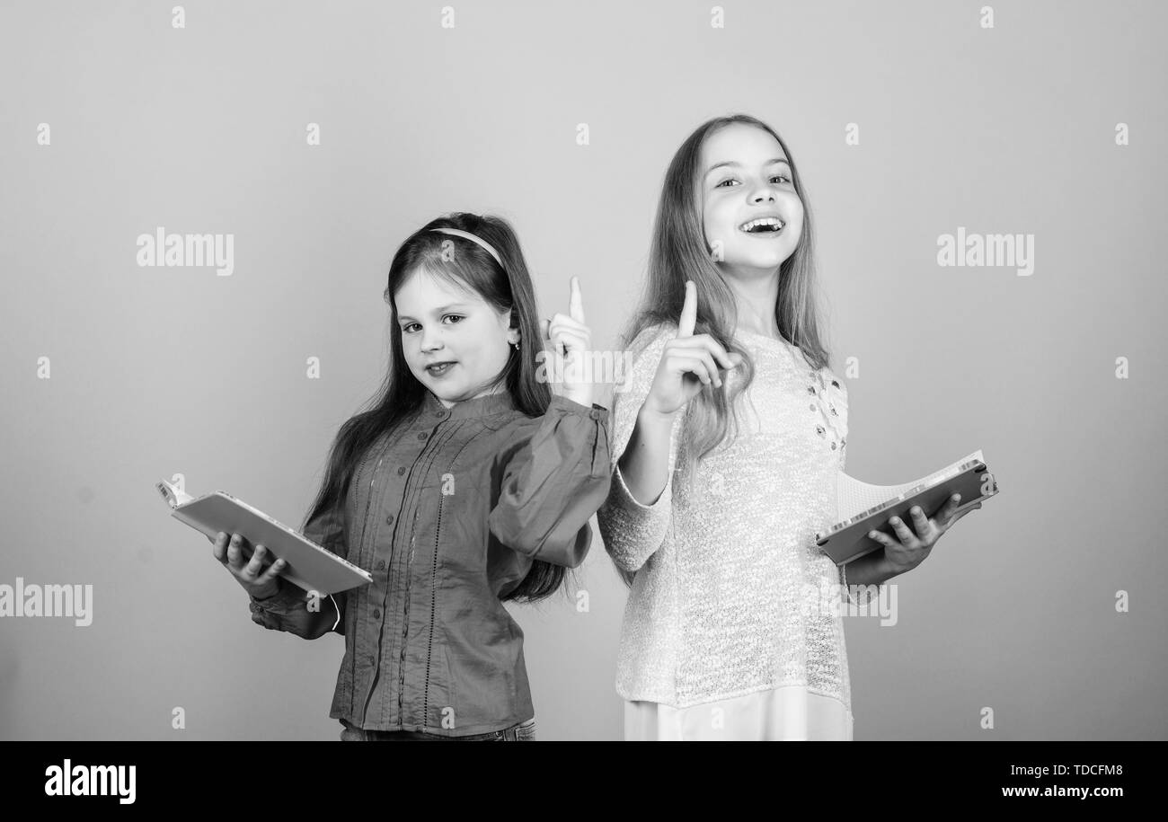 Really busy. students reading a book. School project. small girls with ...