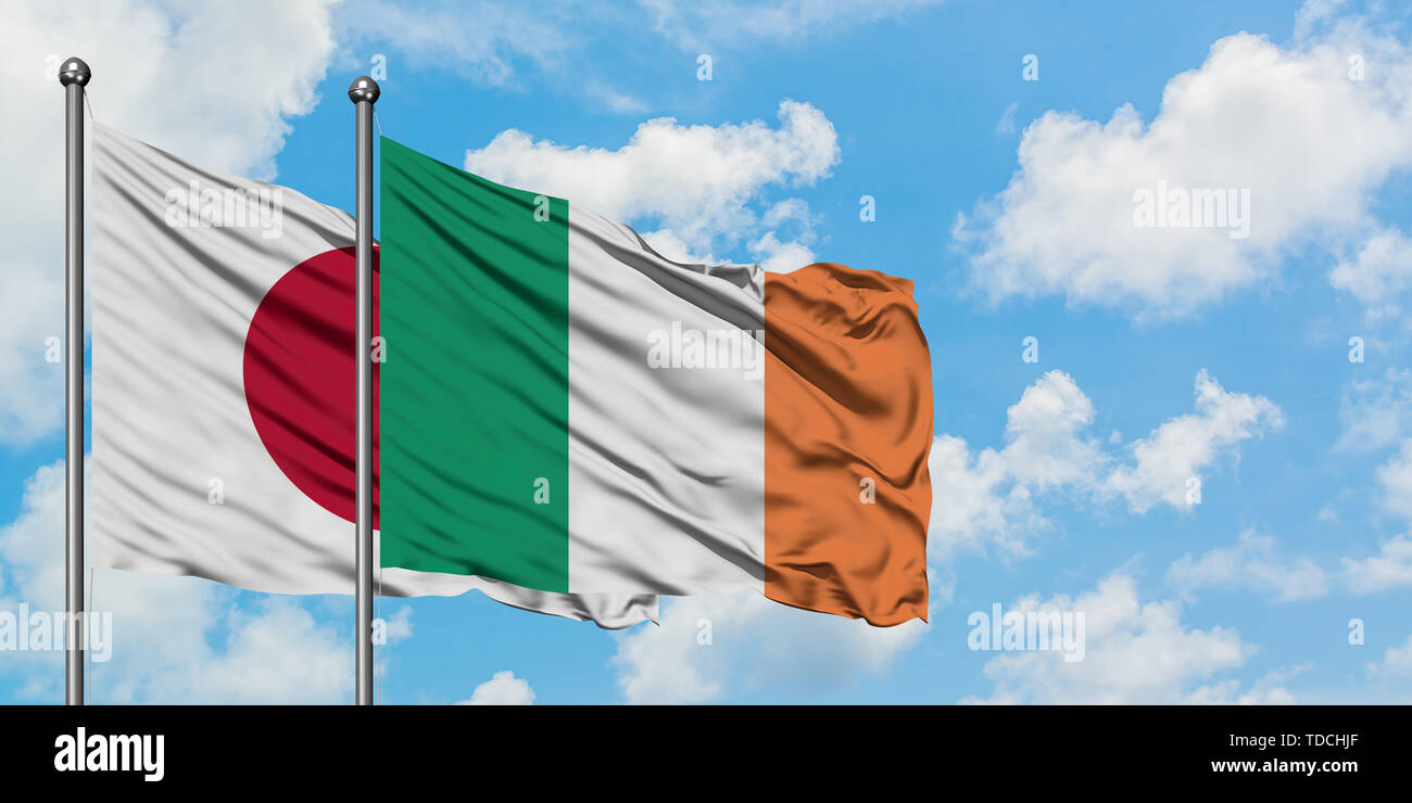 Japan and Ireland flag waving in the wind against white cloudy blue sky ...