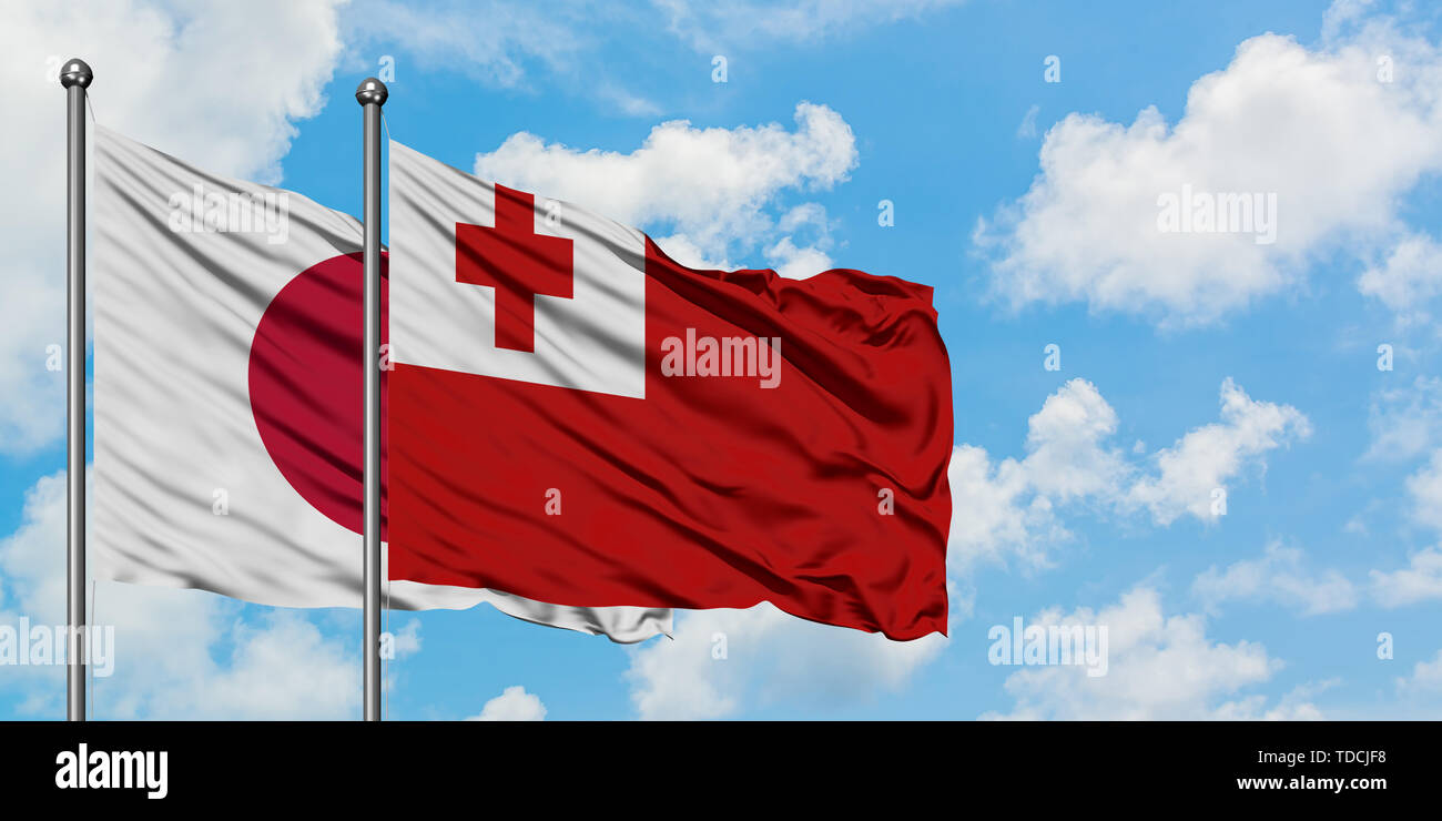 Japan and Tonga flag waving in the wind against white cloudy blue sky ...