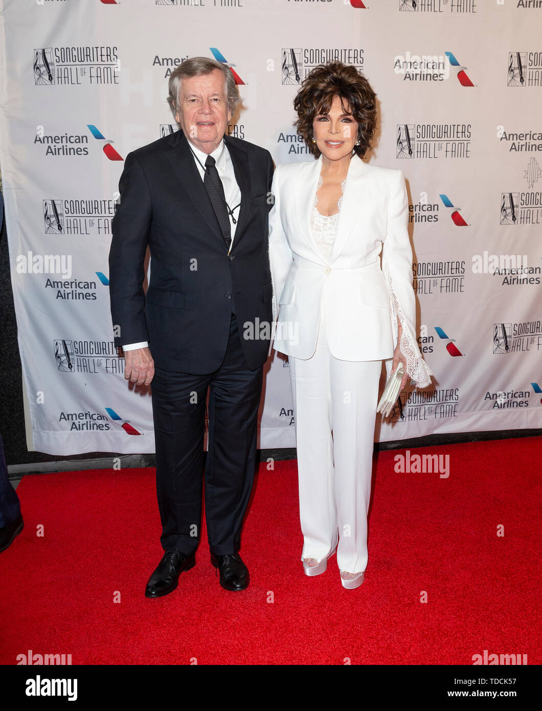 Guest & Carole Bayer Sager wearing suit by Alexander McQueen attend ...