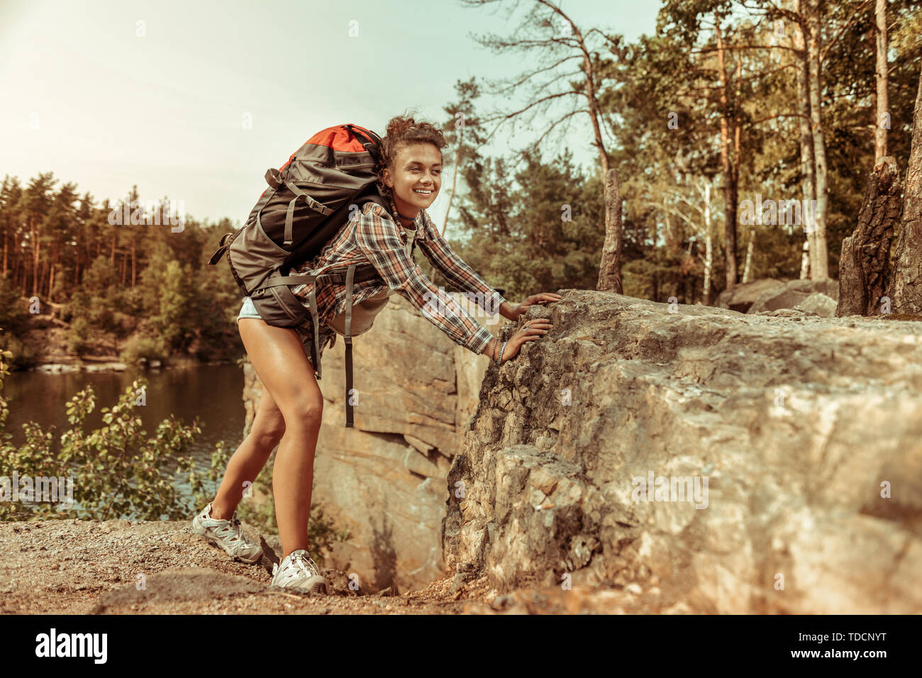 Beautiful positive active woman climbing a cliff Stock Photo - Alamy