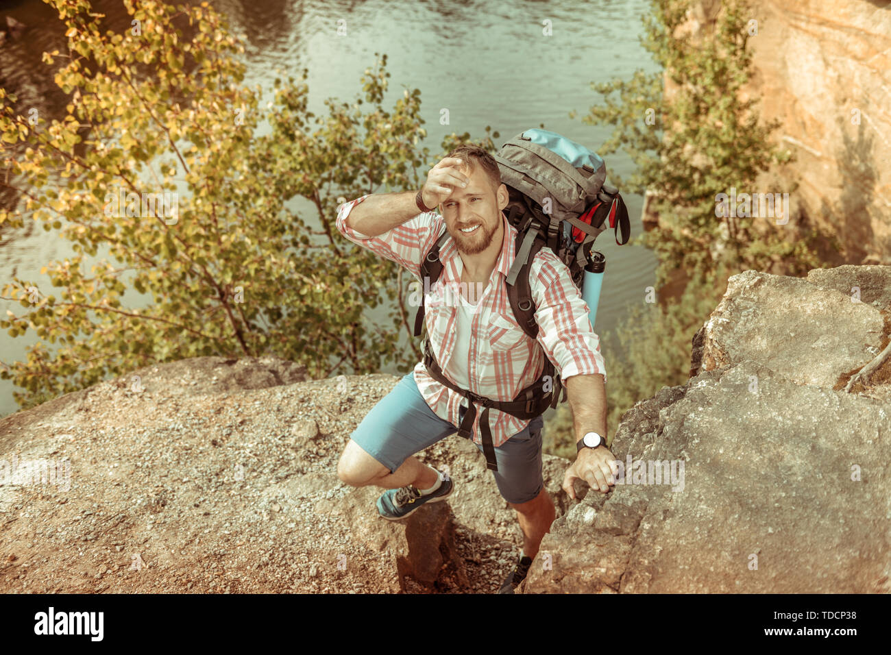 Handsome tired man climbing the hill alone Stock Photo - Alamy