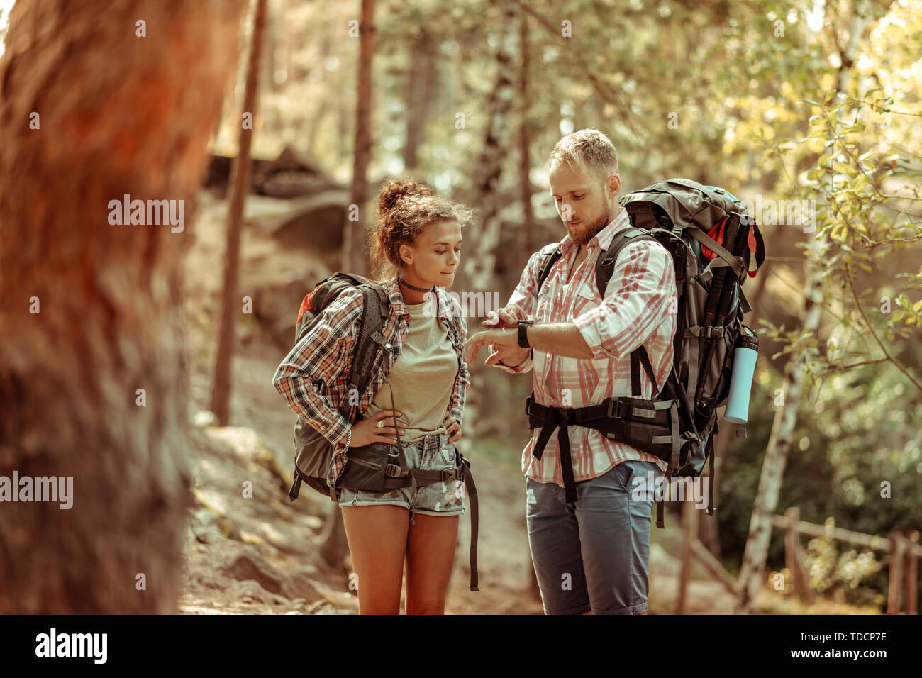 Serious young man looking at his watch Stock Photo - Alamy
