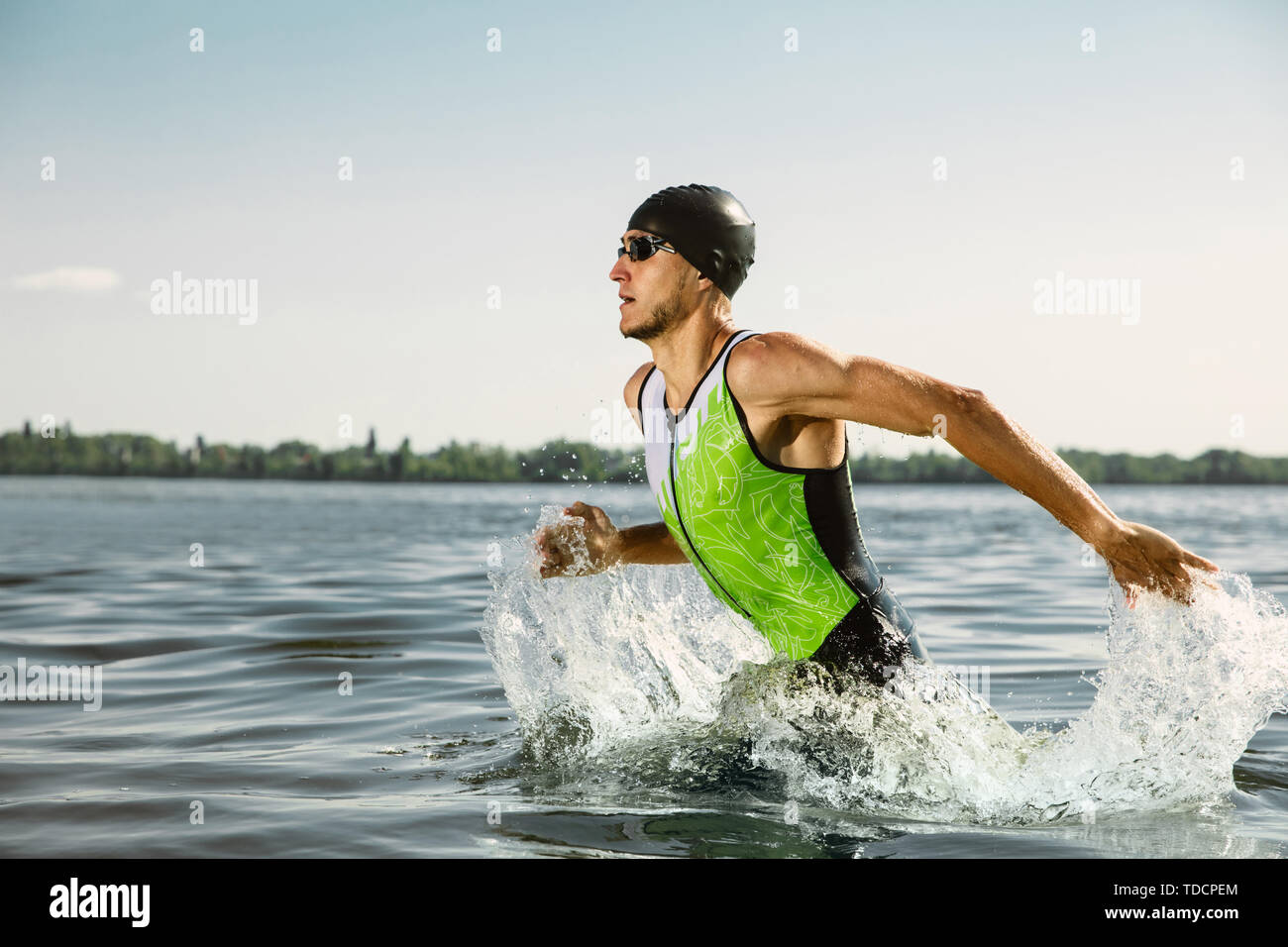 Professional triathlete swimming in river's open water. Man wearing ...