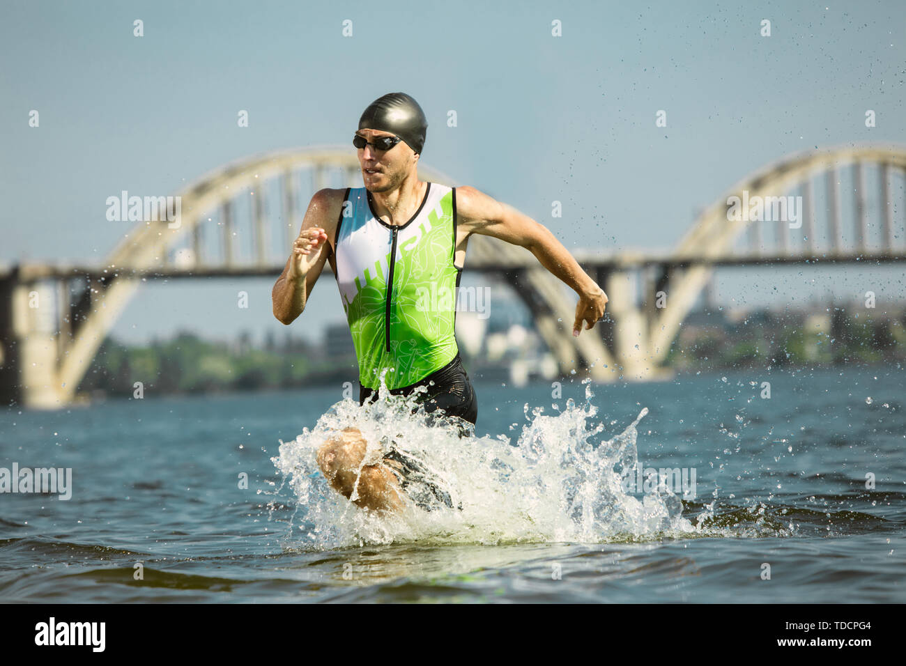 Professional triathlete swimming in river's open water. Man wearing ...