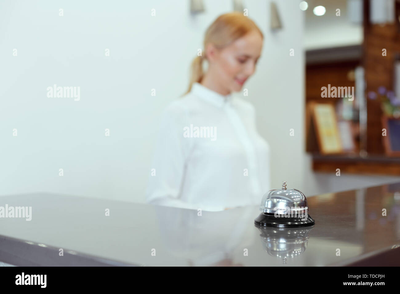 Happy female receptionist standing at hotel counter Stock Photo - Alamy