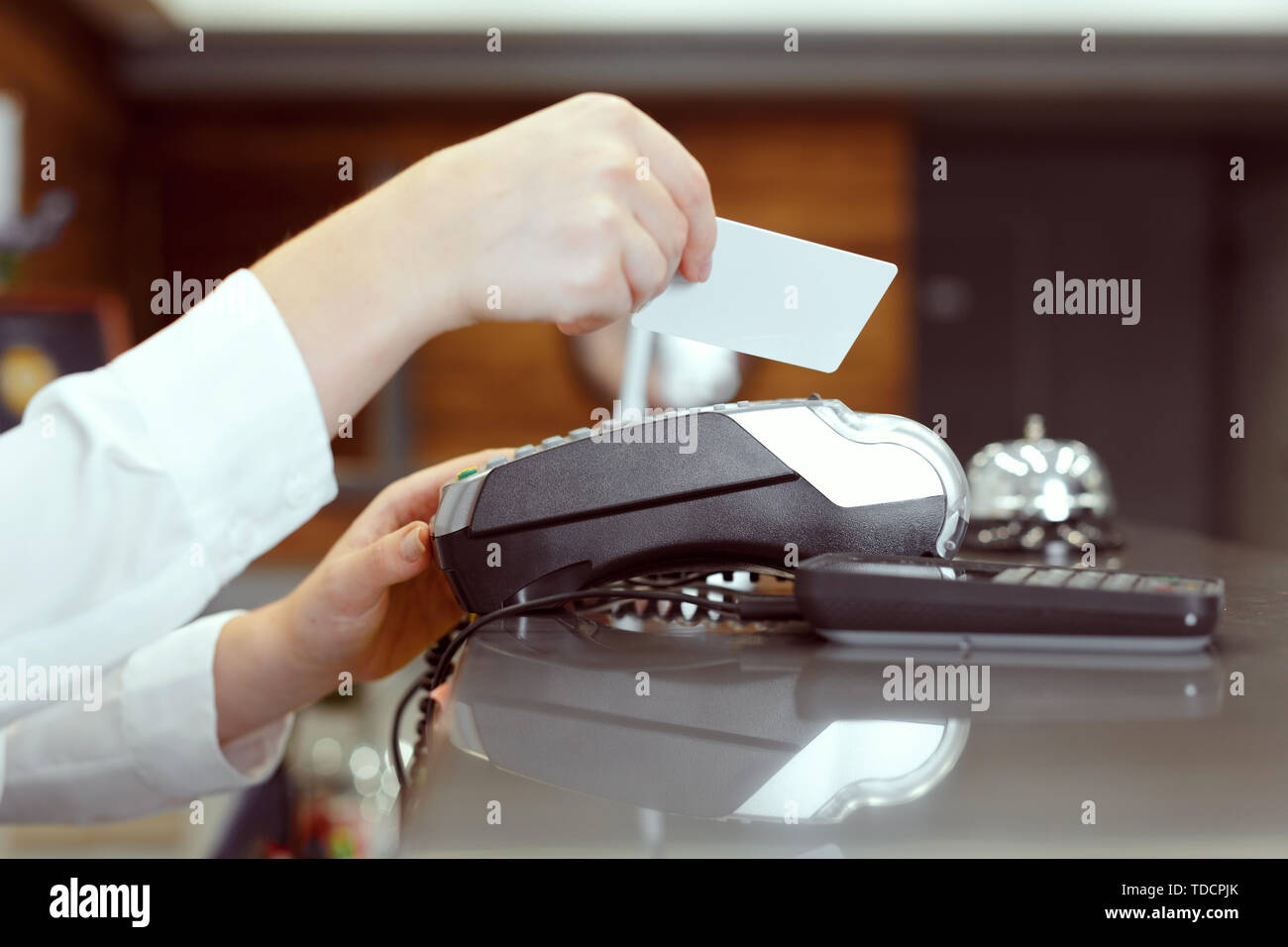 Guest at hotel reception paying with check during check-in Stock Photo ...