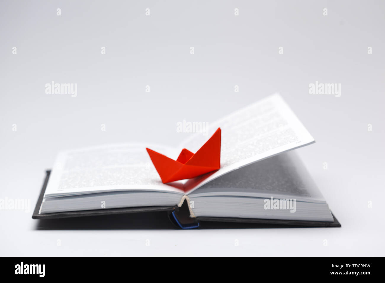 Origami paper boat on a book Stock Photo - Alamy