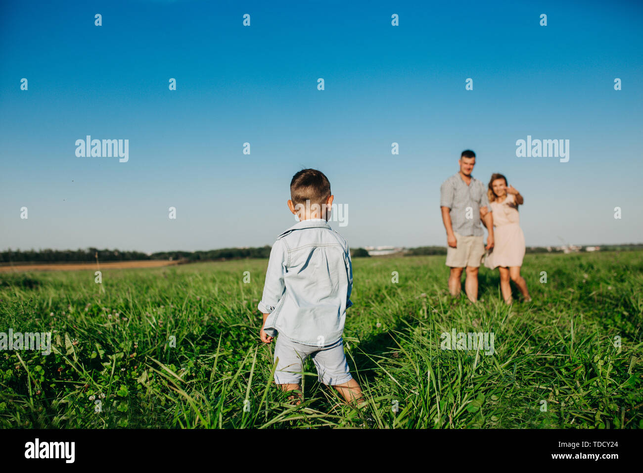 Happy boy with parents running in park. Summertime Stock Photo - Alamy