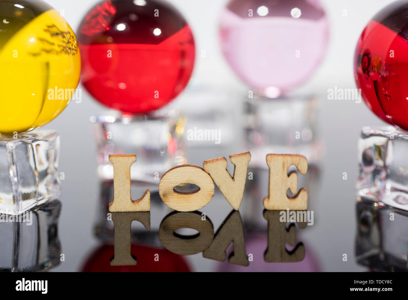 Abstract composition of love. Isolated wooden letters and glass balls ...