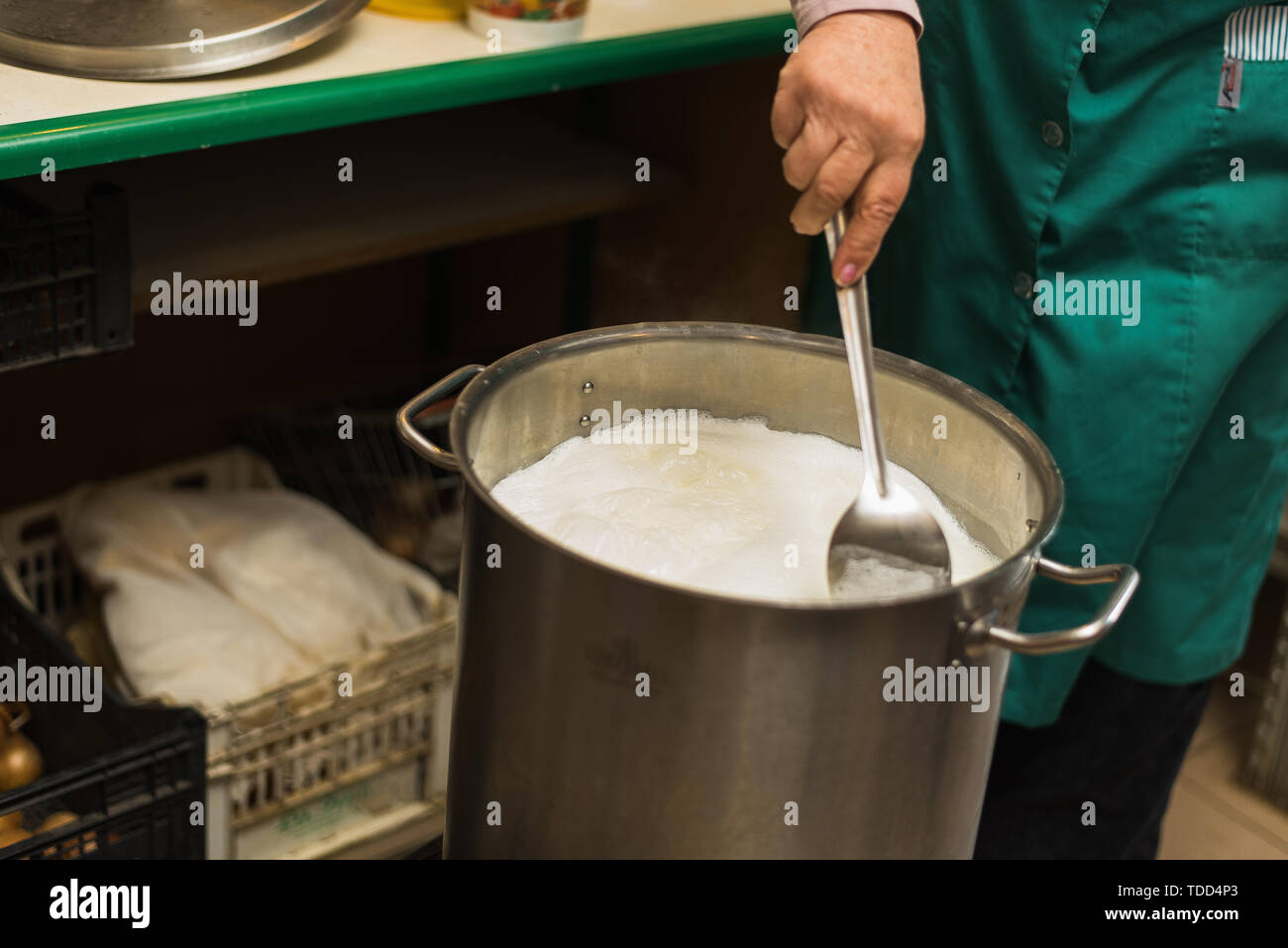 Cooking cottage cheese and cheese at home. Man creates cheese, heating ...