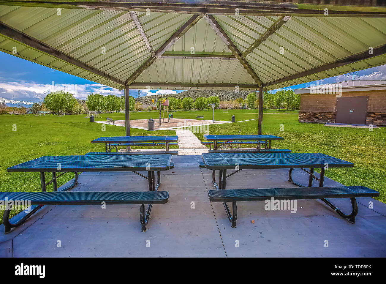 Outdoor eating area inside a pavilion surrounded by lush grasses and ...