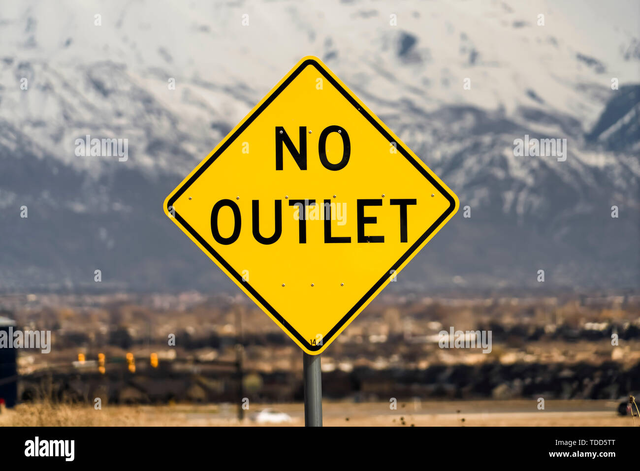 Close up view of a bright yellow and black No Outlet road sign. Snow ...