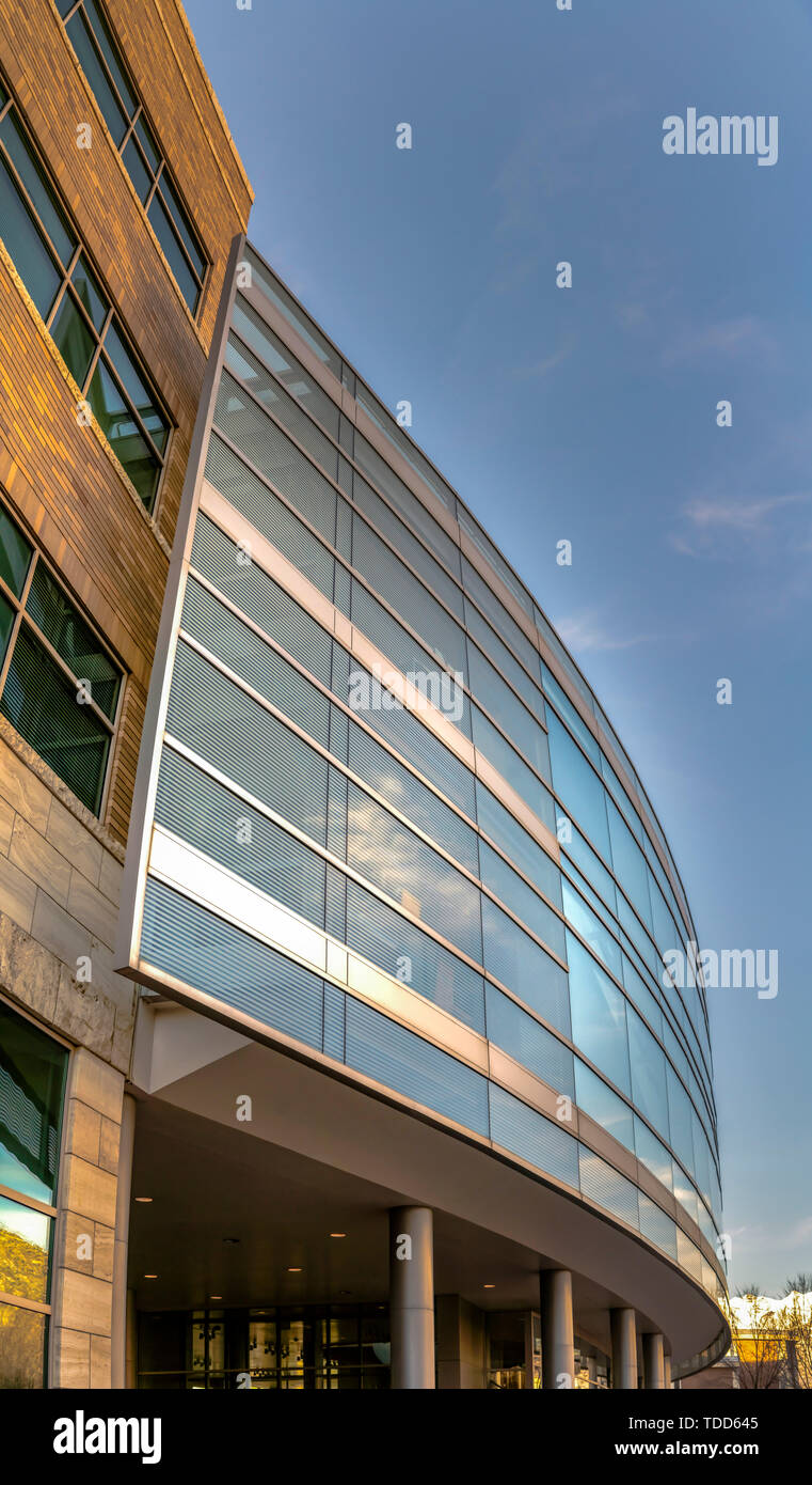 Exterior of a modern building seen from below with blue sky background ...