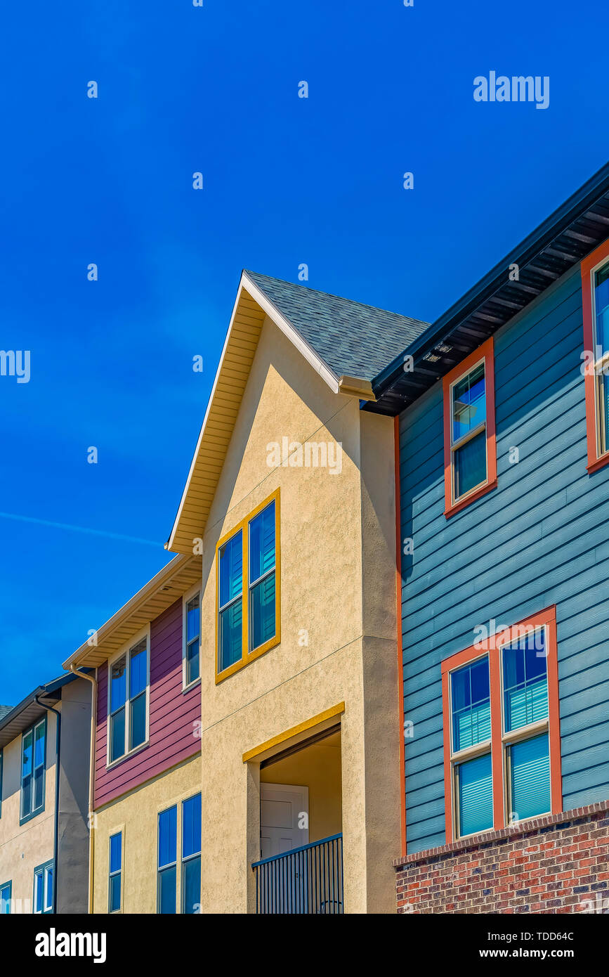Exterior view of houses with balcony and multi colored wall. Clear and ...