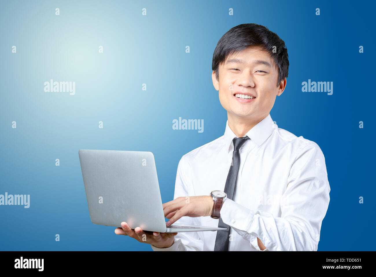 young smiling asian businessman holding laptop Stock Photo - Alamy